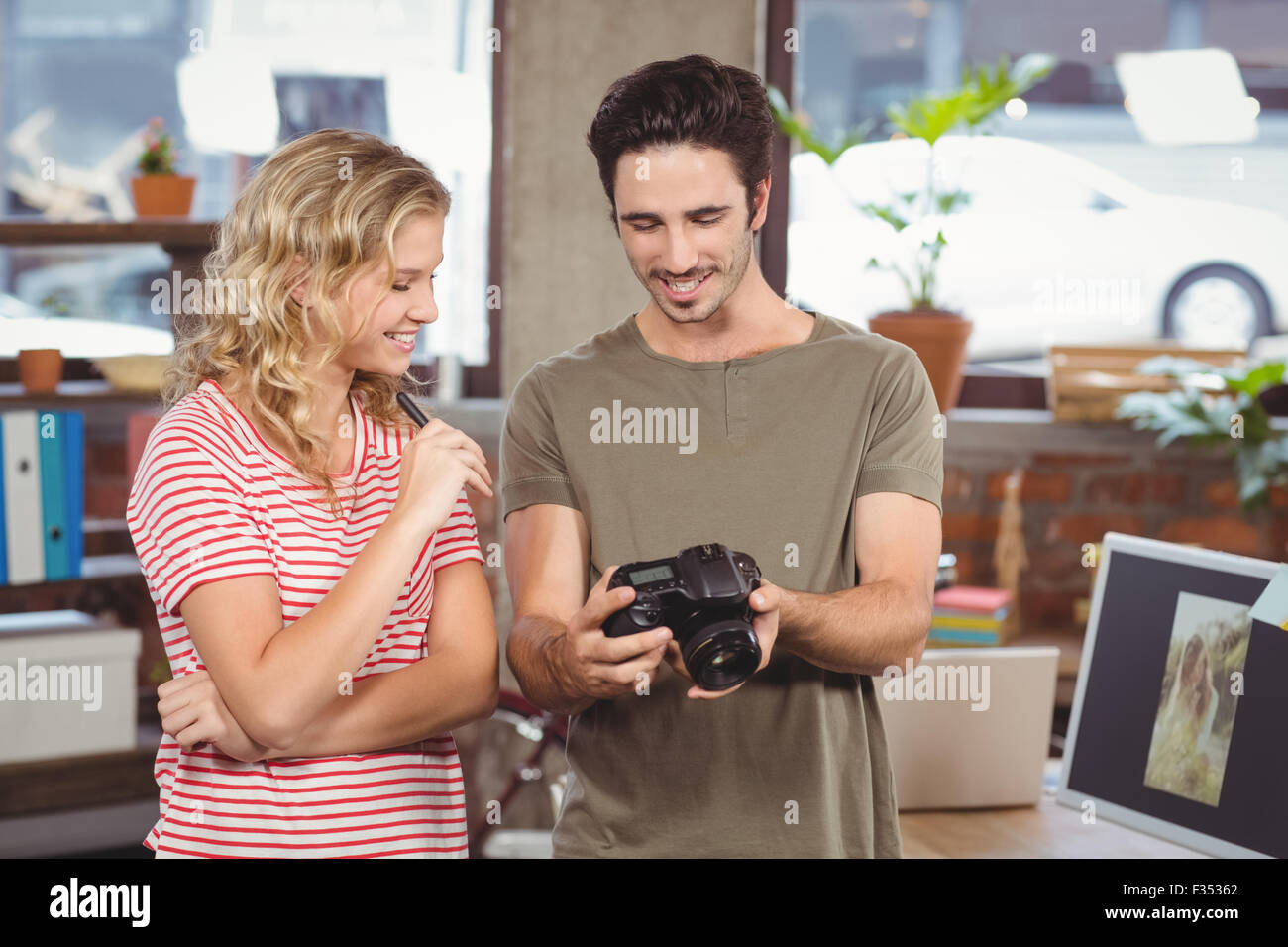 Businessman showing camera to colleague inn office Stock Photo - Alamy