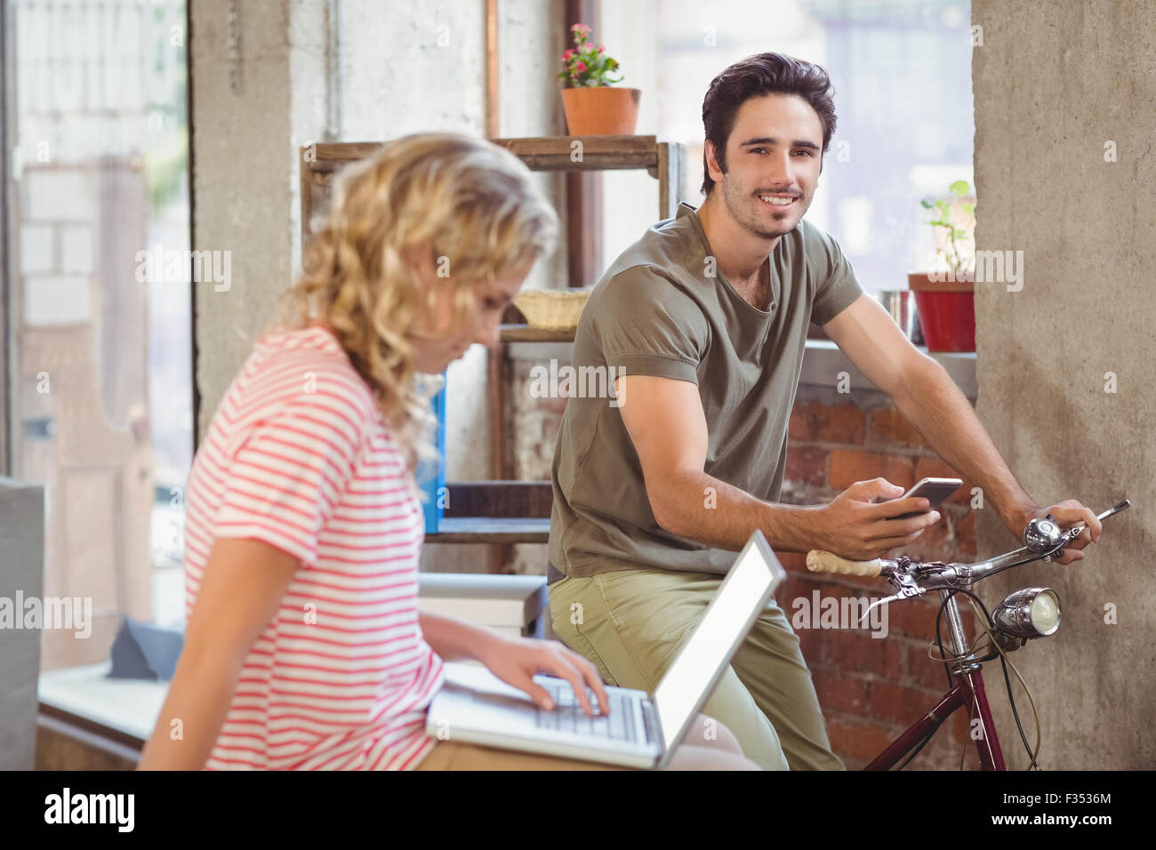 Man on bicycle using smartphone in office Stock Photo - Alamy