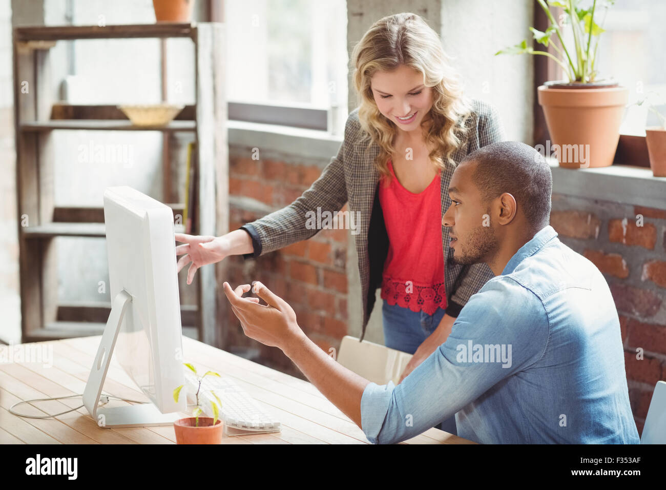 Man and woman pointing towards computer Stock Photo - Alamy