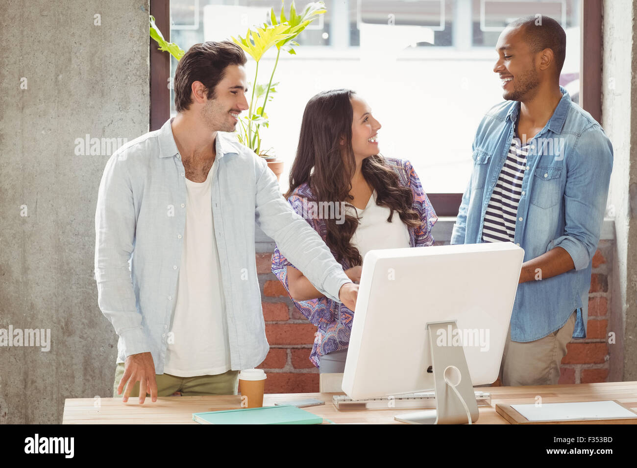 Business people smiling while pointing towards computer Stock Photo - Alamy