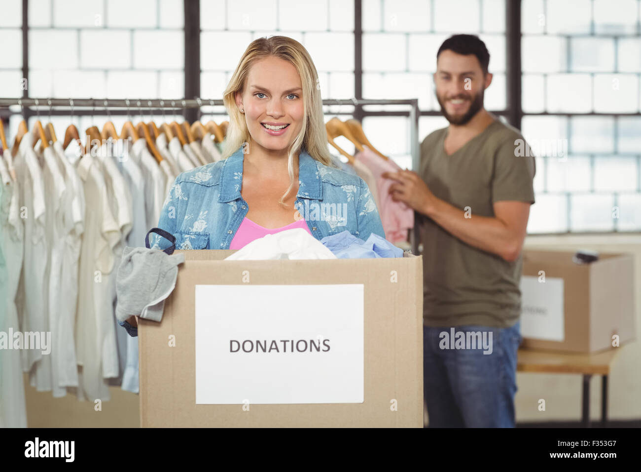 Portrait of woman holding donation box while standing Stock Photo - Alamy