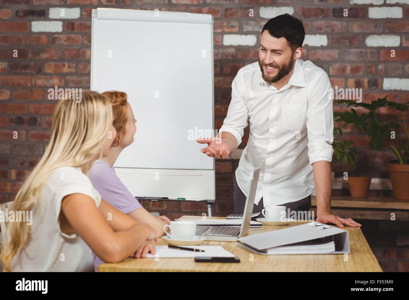 Businessman smiling while explaining to colleagues Stock Photo - Alamy