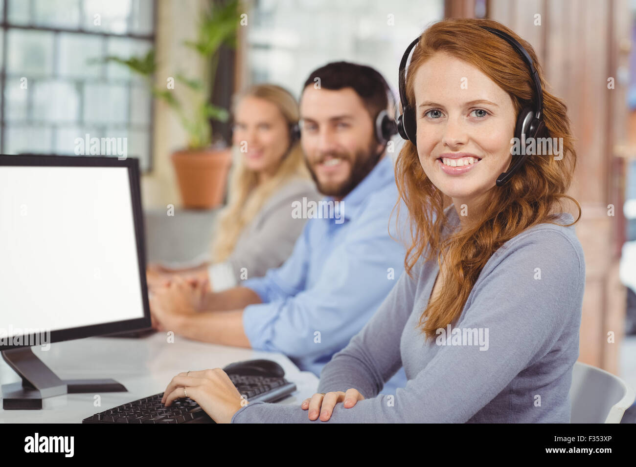 Portrait of smiling operators working in office Stock Photo - Alamy