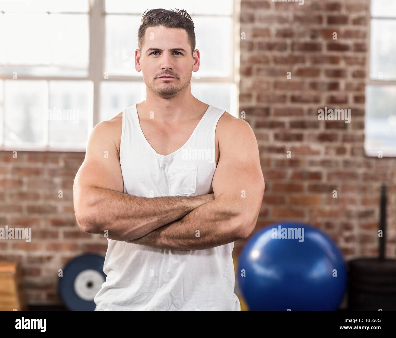 Portrait of muscular man with arms crossed Stock Photo - Alamy
