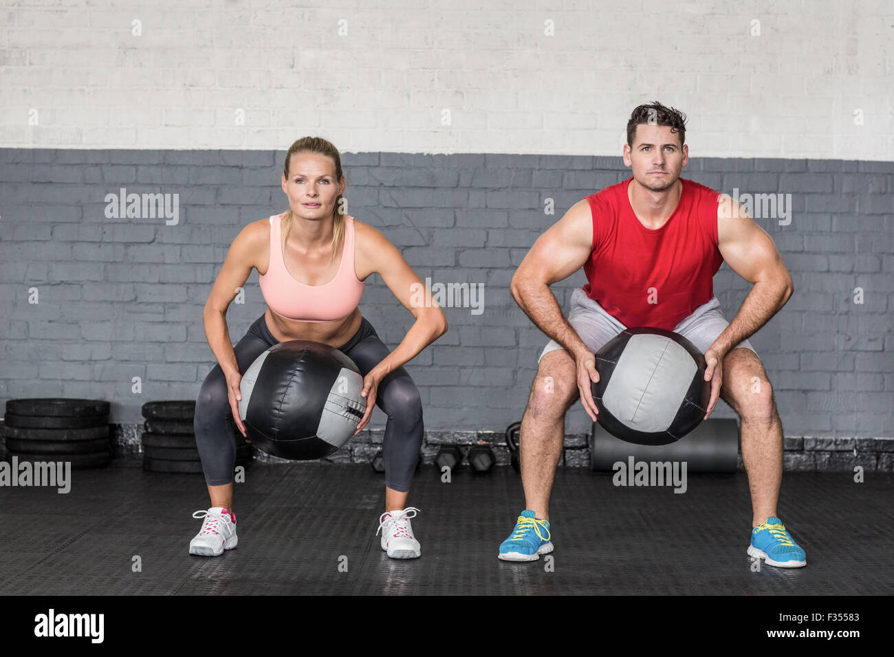 Muscular couple doing ball exercise Stock Photo - Alamy