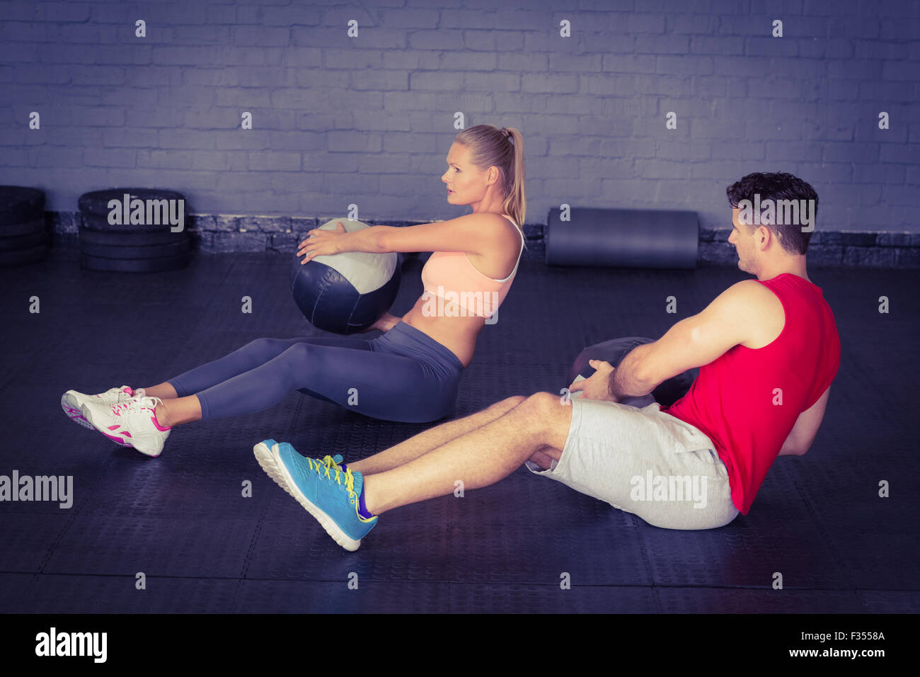 Muscular couple doing ball exercise Stock Photo - Alamy
