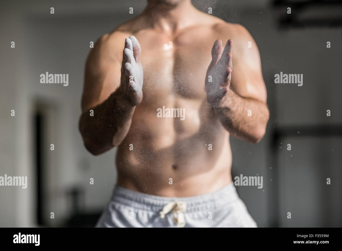 Muscular man shaking chalk off his hands Stock Photo - Alamy