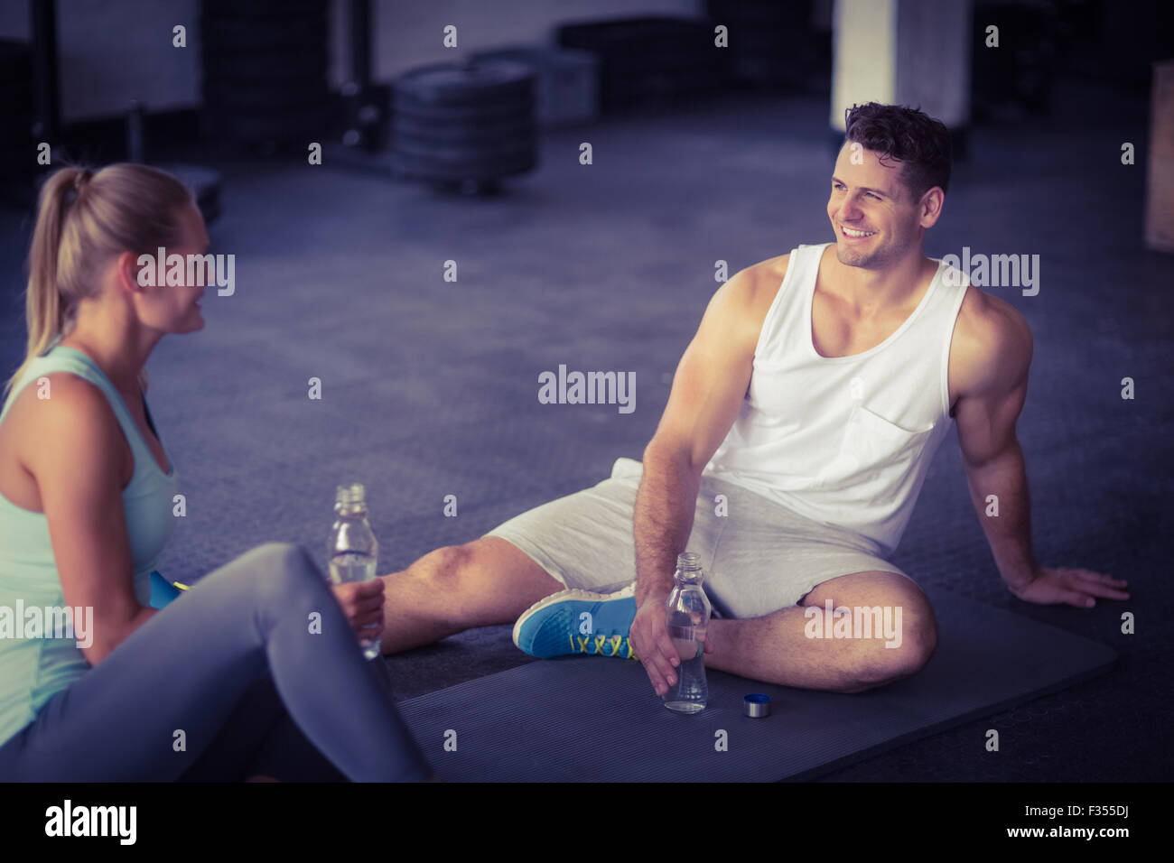Sitting young couple drinking water together Stock Photo - Alamy