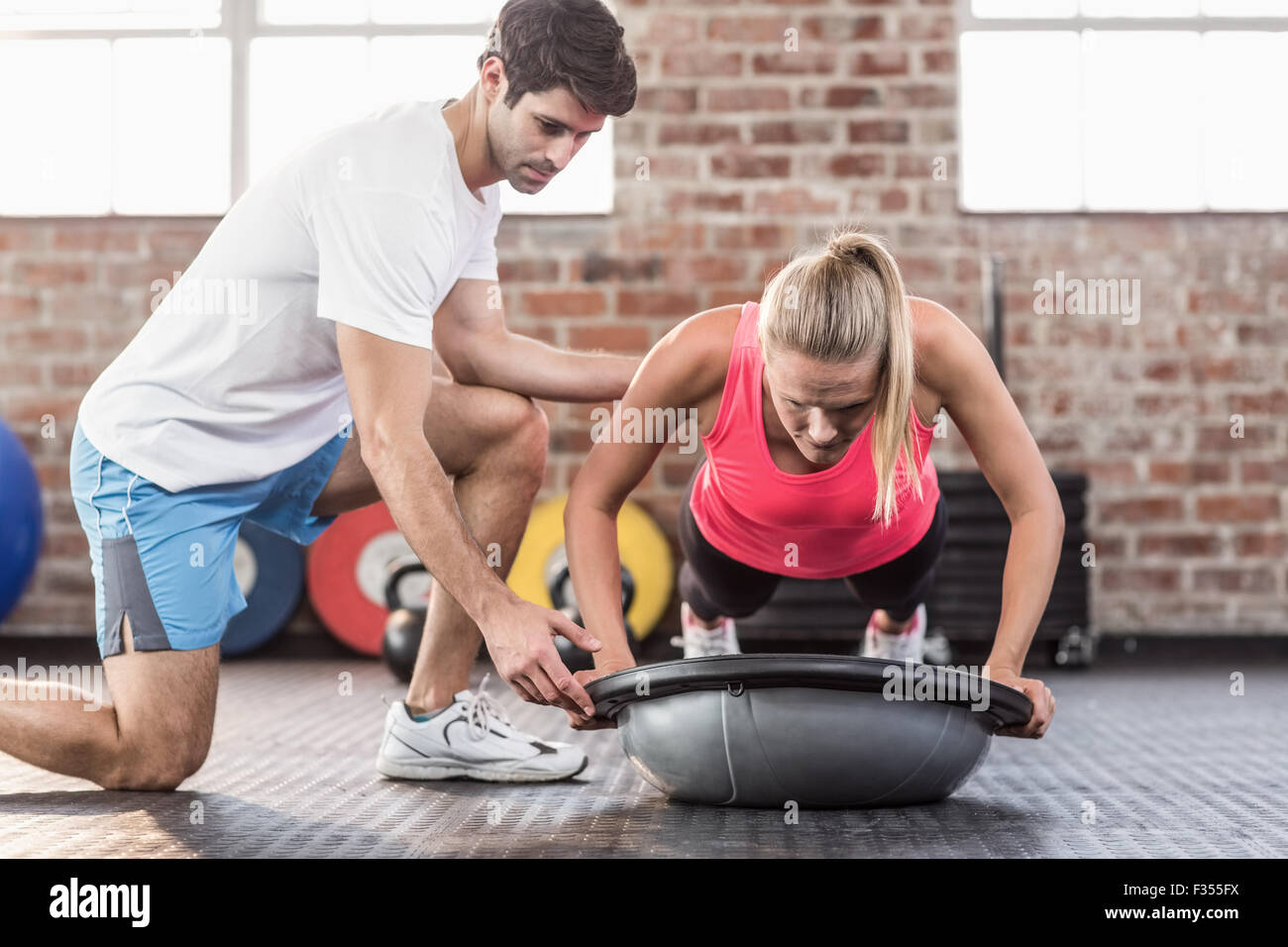Trainer motivating client doing push ups Stock Photo - Alamy