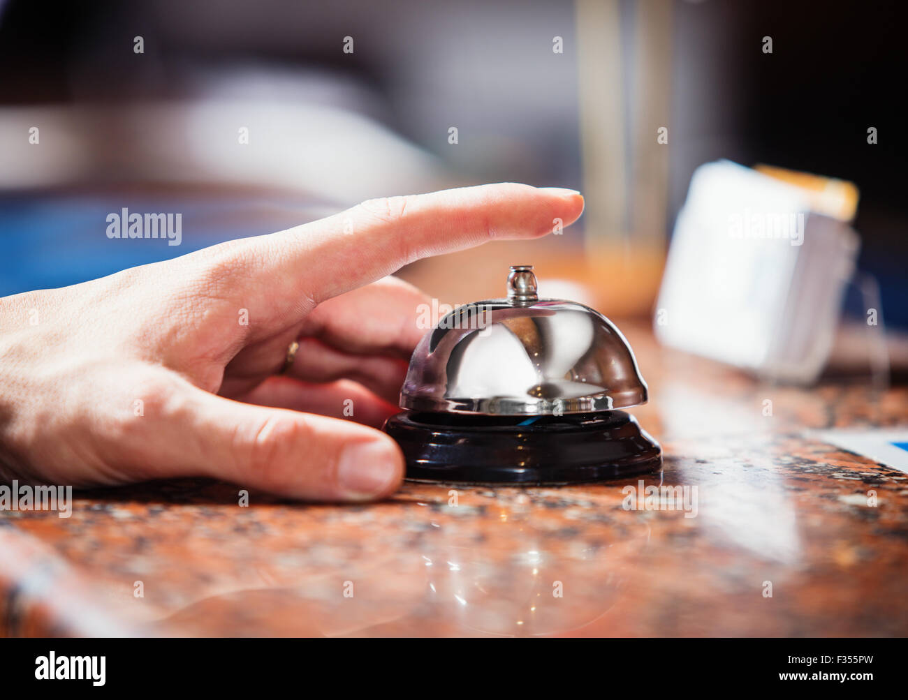 Close up photo of hand ringing a hotel reception service bell to ...
