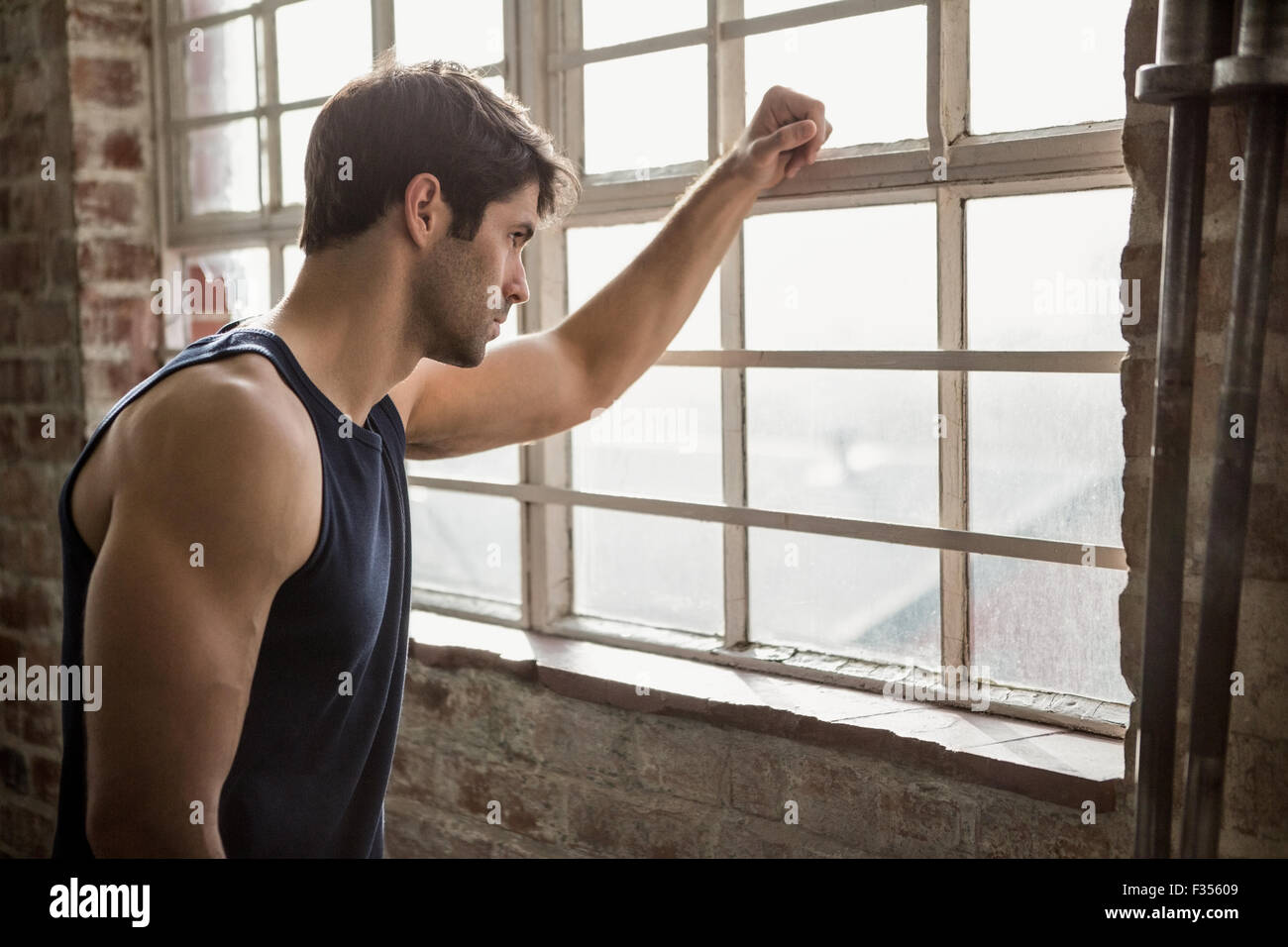 Man looking outside window Stock Photo - Alamy