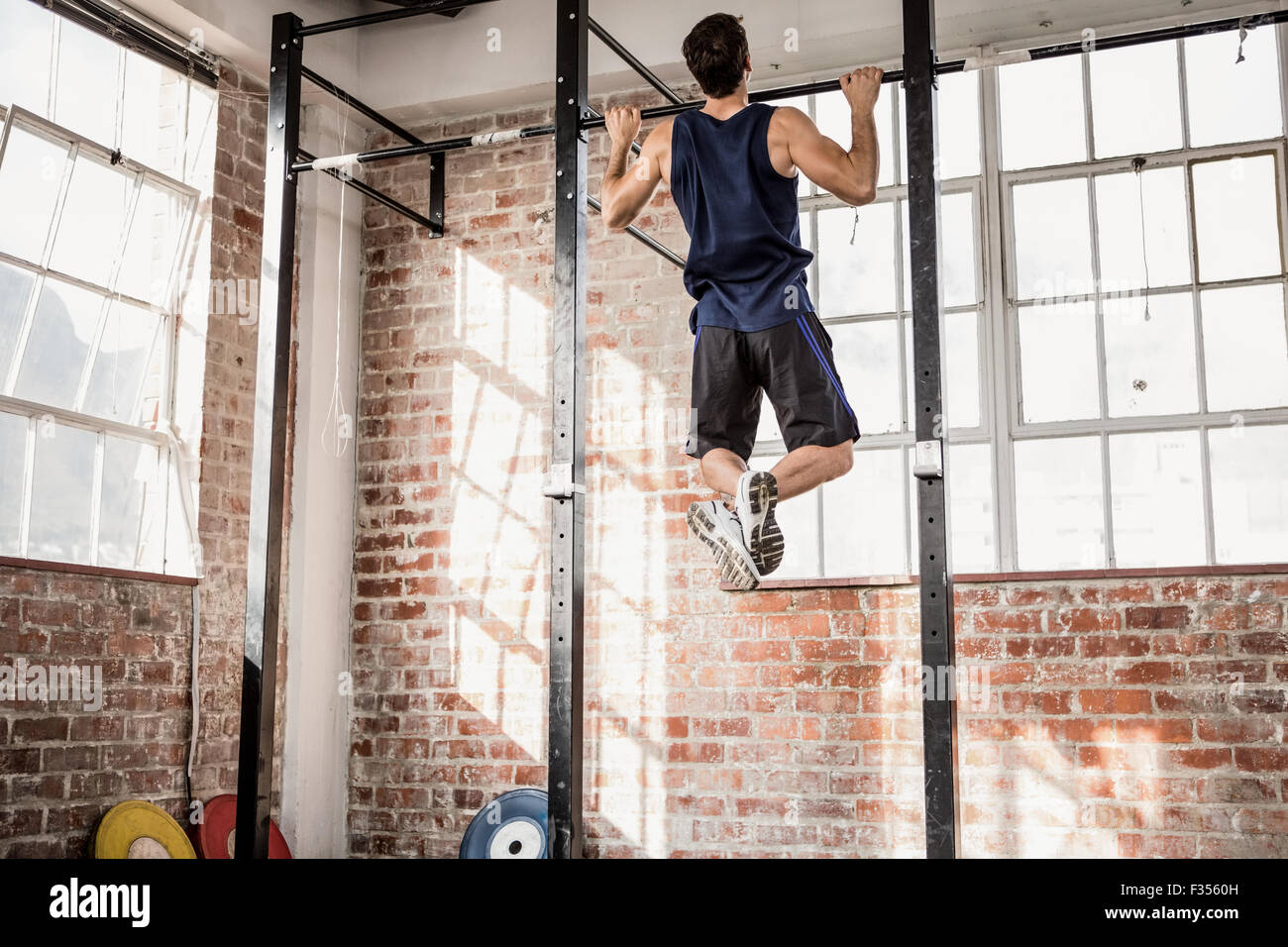 Rear view of muscular man doing pull ups Stock Photo - Alamy