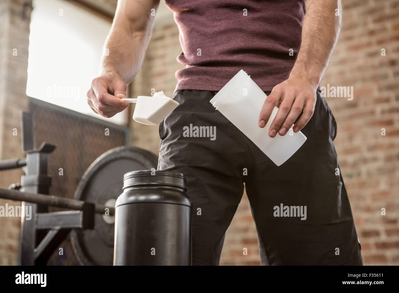 Midsection of man adding supplement to bottle Stock Photo - Alamy