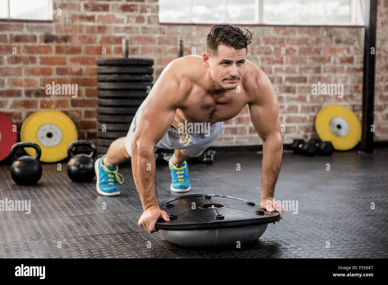 Muscular man doing bosu push ups Stock Photo - Alamy