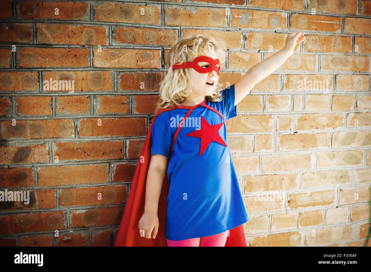 Cute little super hero girl against brick wall. Superhero concept Stock ...