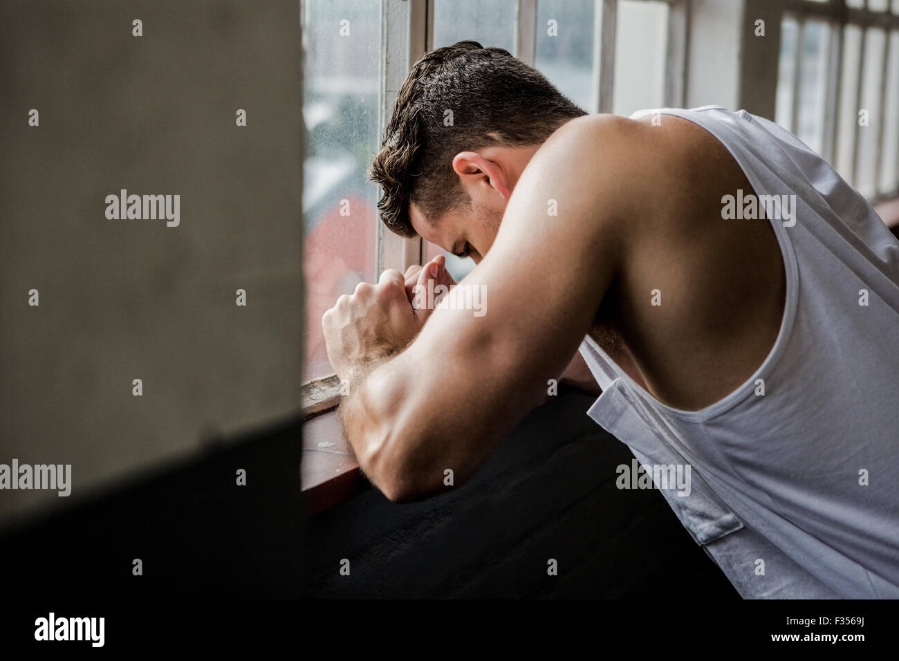 Muscular man leaning on window Stock Photo - Alamy