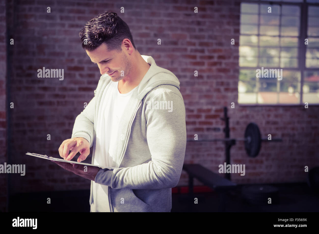 Muscular man holding clipboard Stock Photo - Alamy