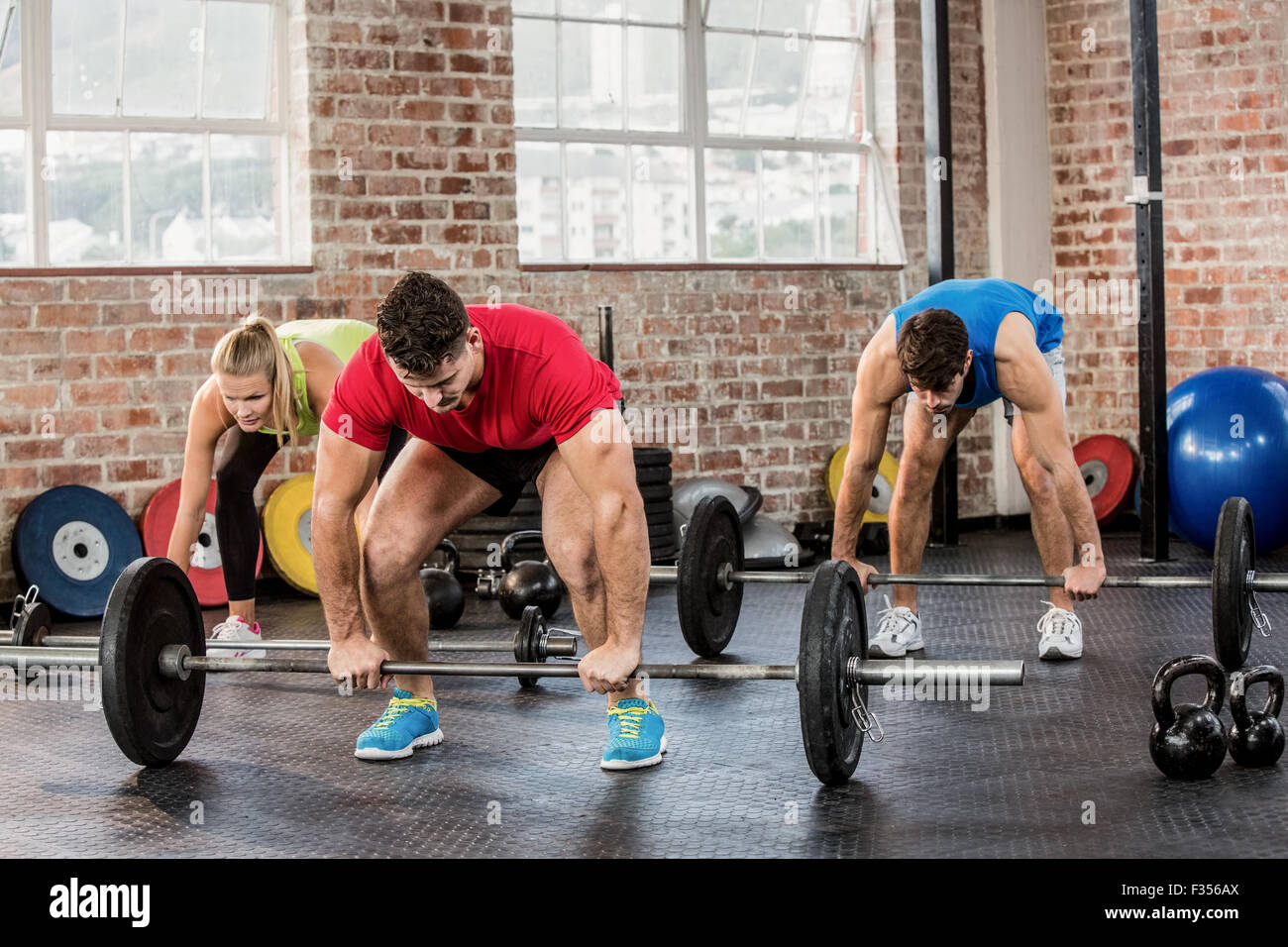 People lifting barbell Stock Photo - Alamy