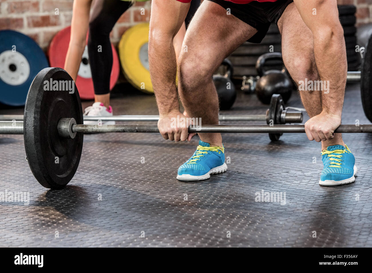 Cropped image of people lifting barbell Stock Photo - Alamy