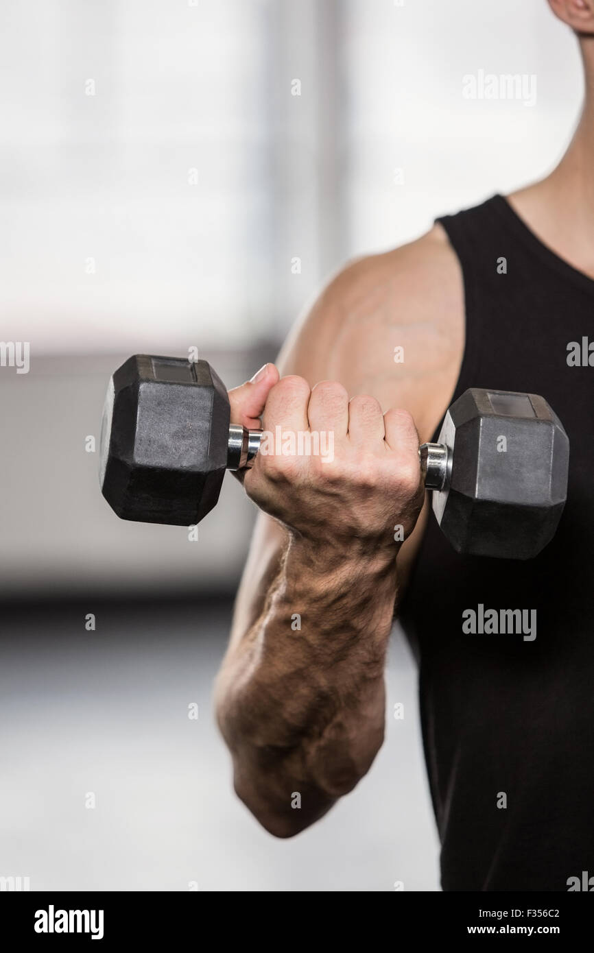 Cropped image of man lifting dumbbell Stock Photo - Alamy