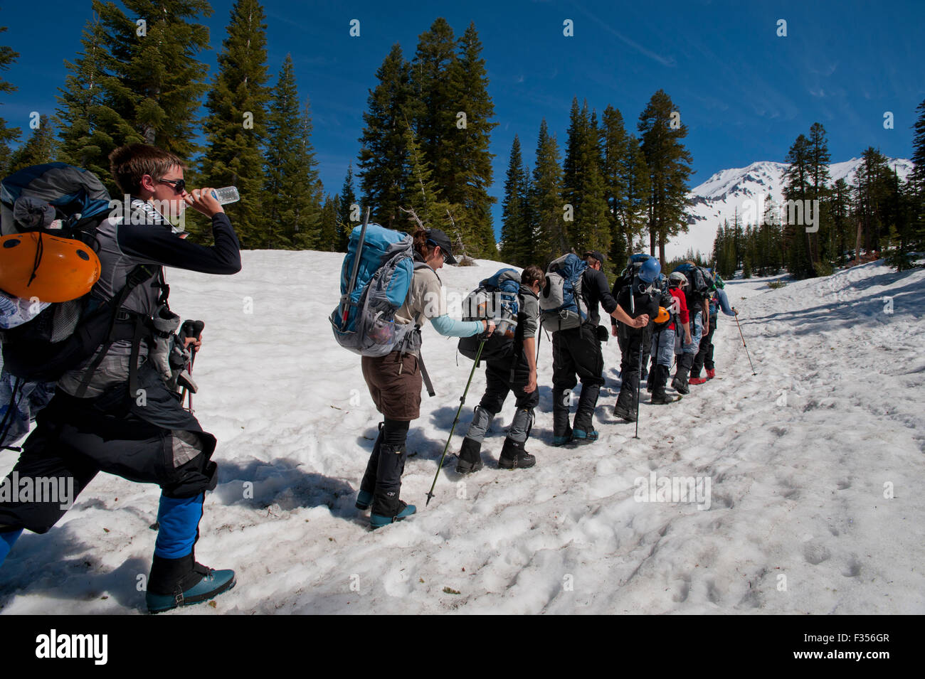 A crew of people hike through the snow on their way to a high camp at ...