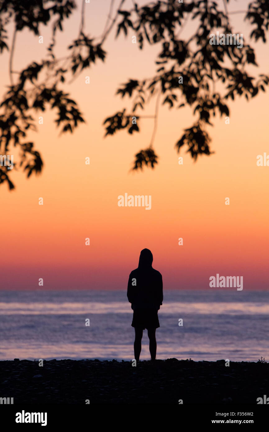 man looking out to the ocean sunrise Stock Photo - Alamy
