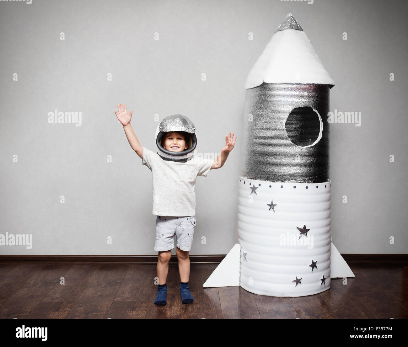 Happy child dressed in an astronaut costume playing with hand made ...