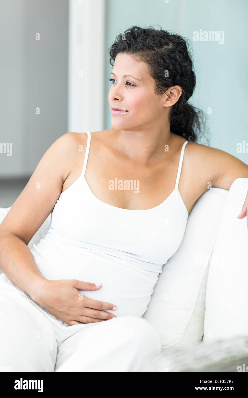 Happy woman sitting on lounge sofa Stock Photo - Alamy