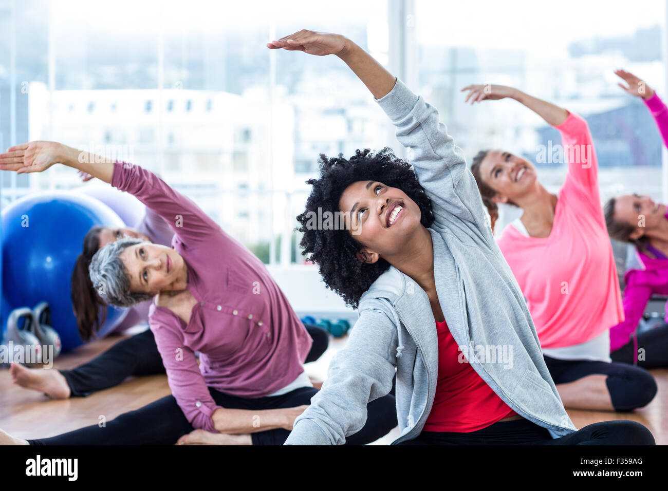 Happy women exercising while arms raised Stock Photo - Alamy
