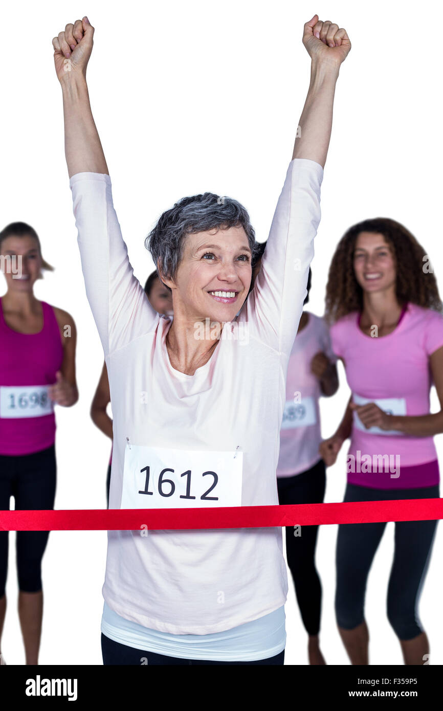 Happy winner athlete crossing finish line with arms raised Stock Photo ...