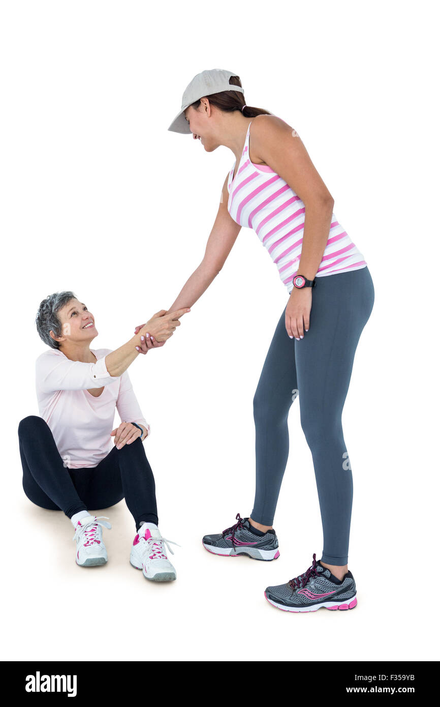 Woman helping happy female friend Stock Photo - Alamy