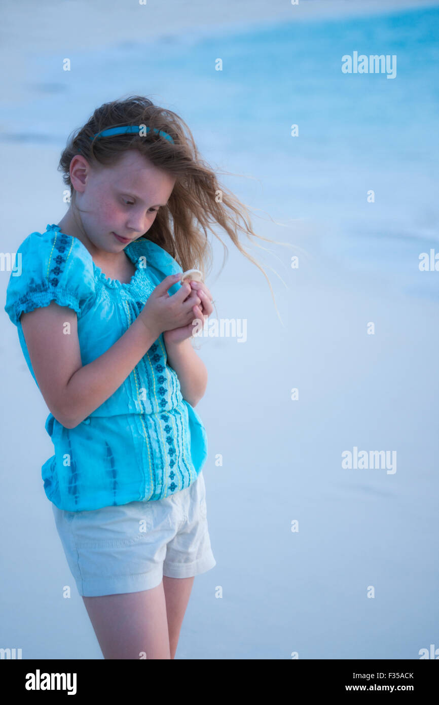 Girl looking at a shell on a Caribbean beach, Grace Bay, Providenciales ...