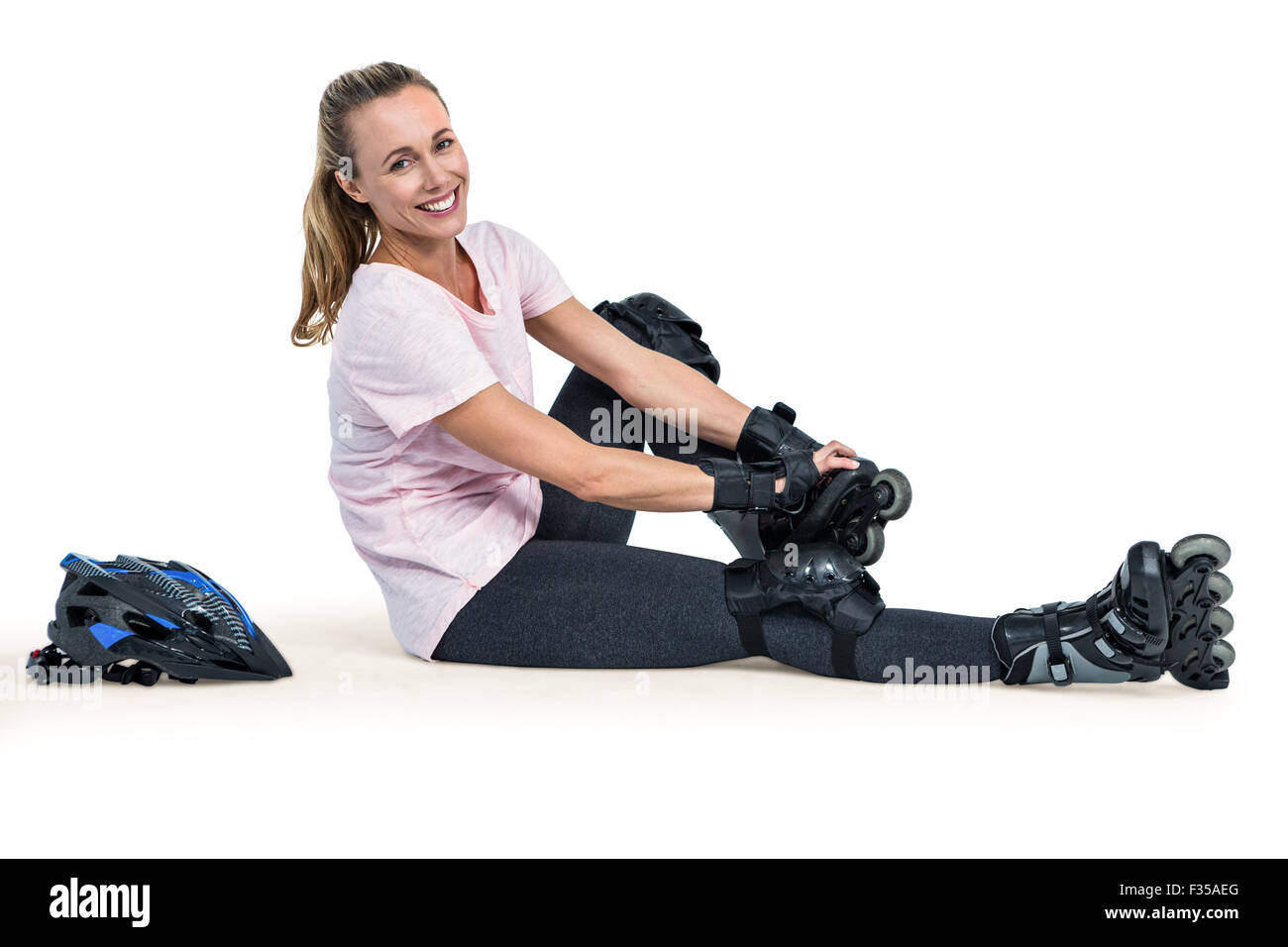 Portrait of cheerful sporty woman wearing inline skates Stock Photo - Alamy