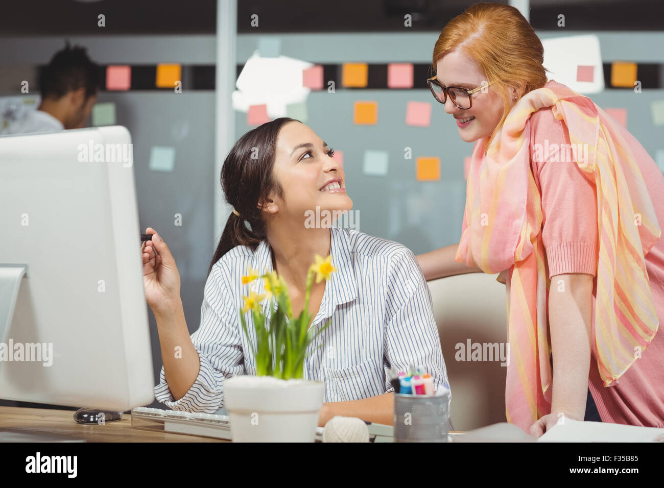 Happy businesswomen using computer in office Stock Photo - Alamy