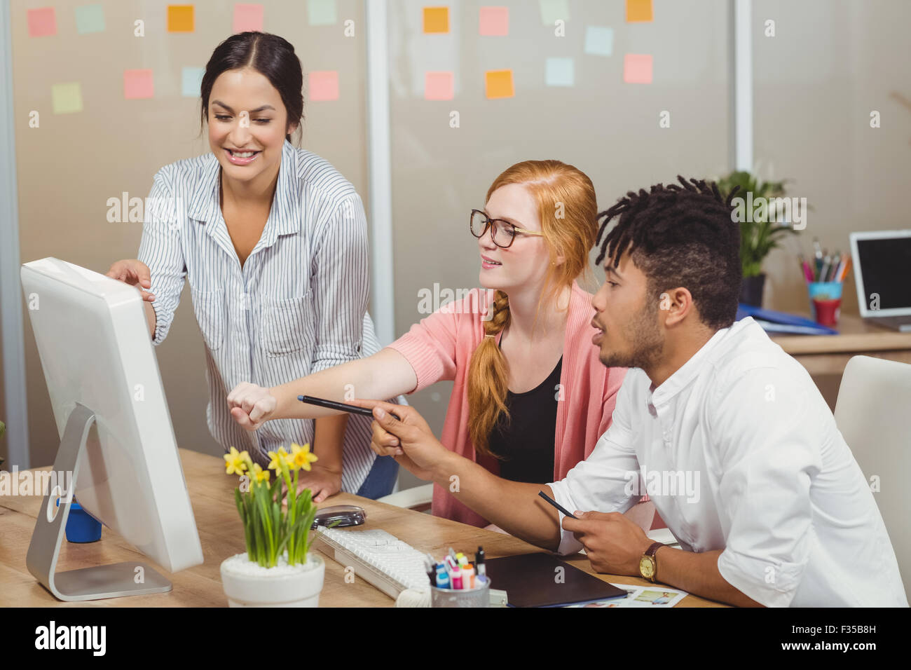 Business people pointing towards computer in office Stock Photo - Alamy