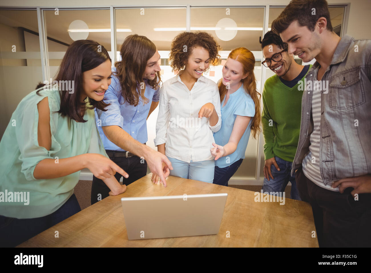 Business people pointing at laptop Stock Photo - Alamy