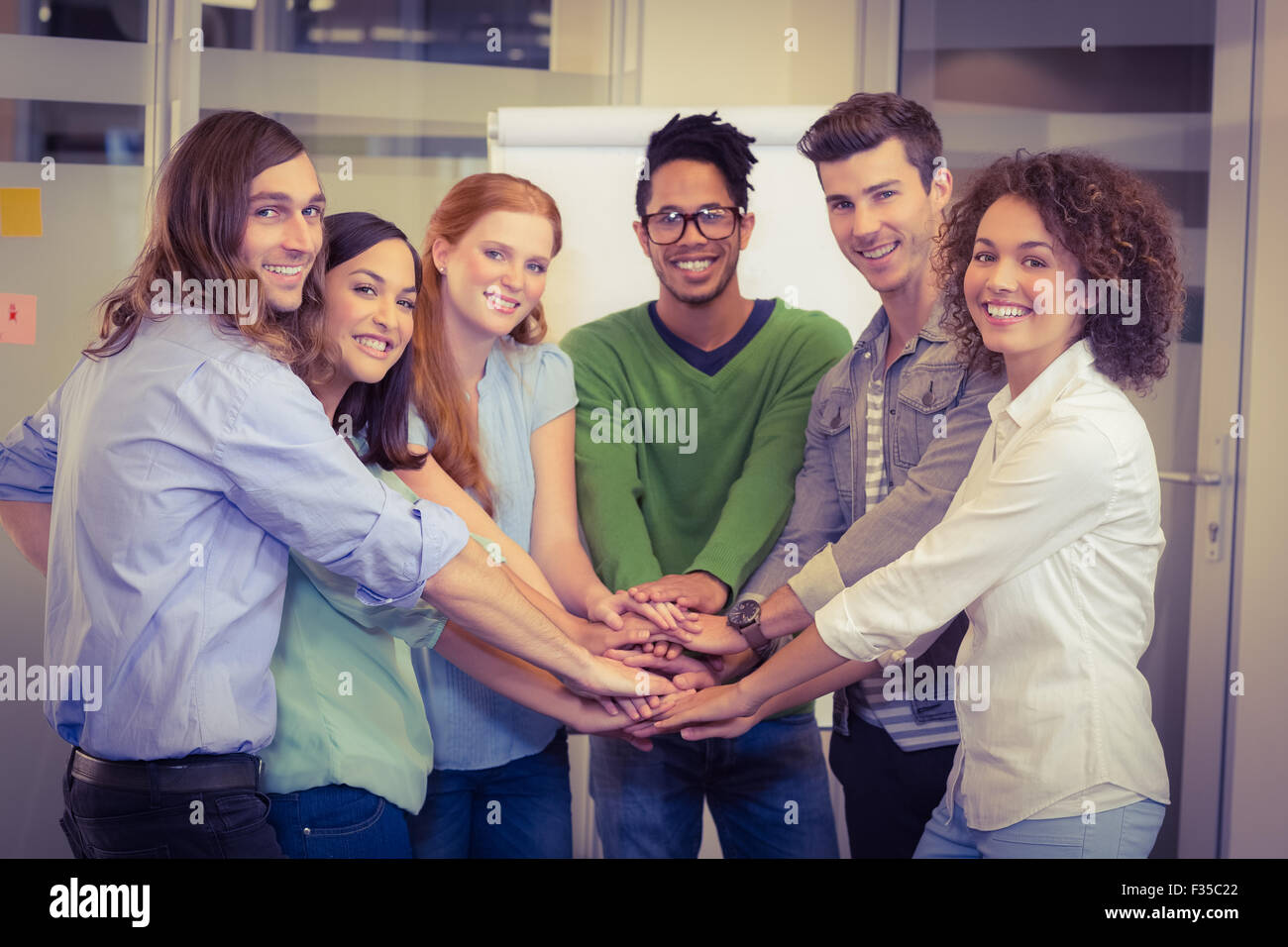 Portrait of smiling business people with hand stacked Stock Photo - Alamy