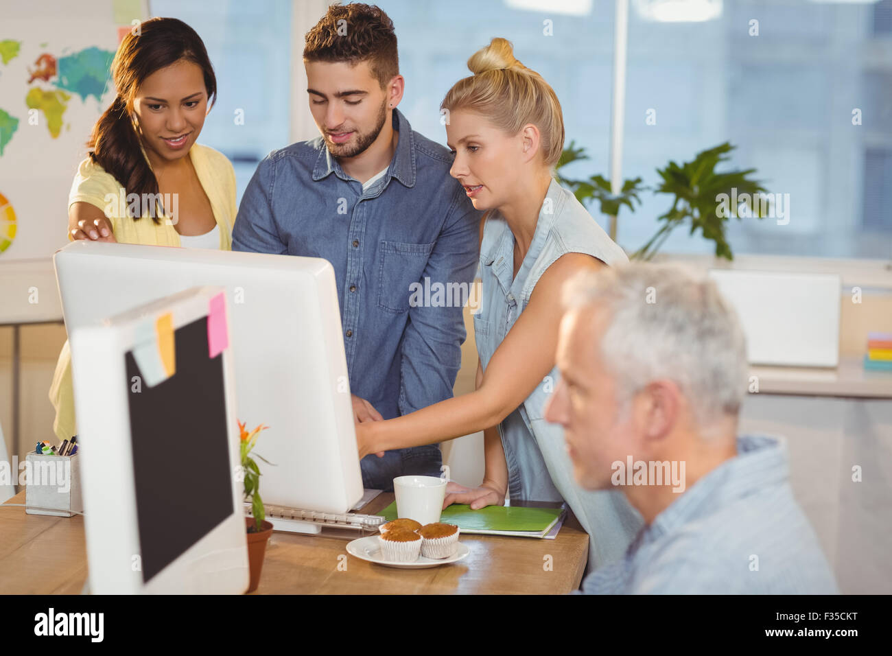 Business people using computer as male colleague working Stock Photo ...