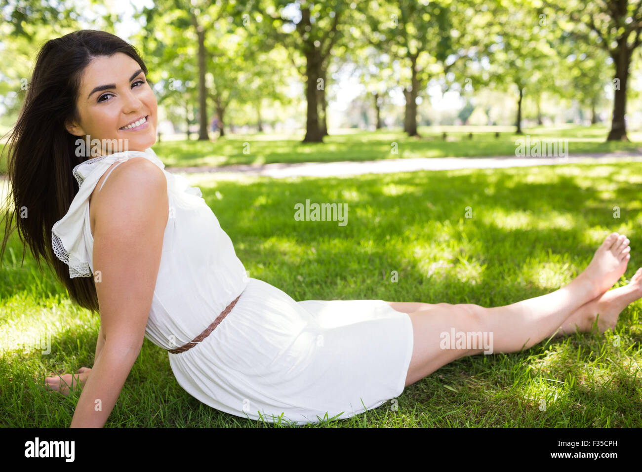 Portrait side view of female relaxing on grassland Stock Photo - Alamy