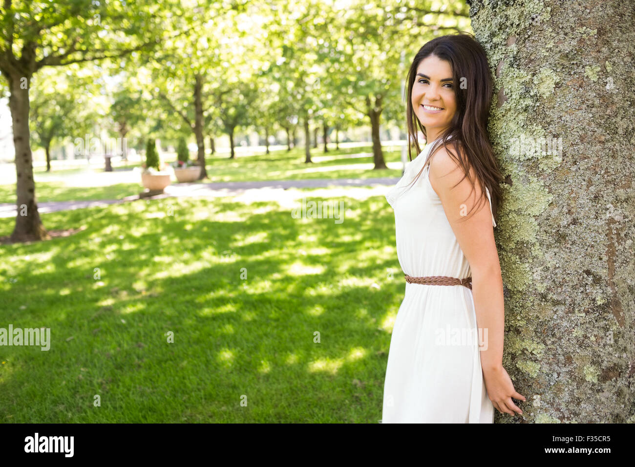 Young woman leaning on tree trunk hi-res stock photography and images ...