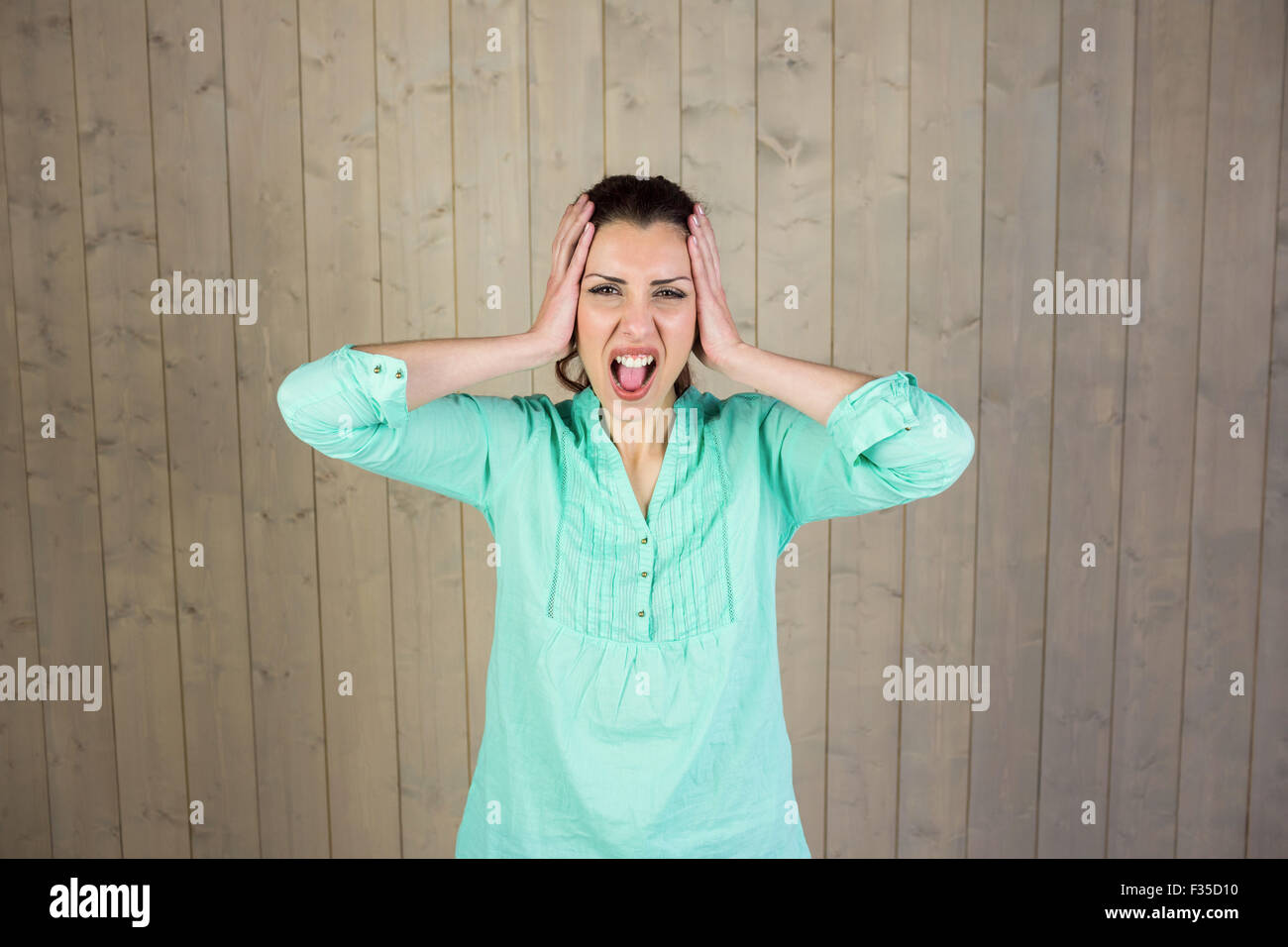 Portrait of woman screaming with head in hands Stock Photo - Alamy
