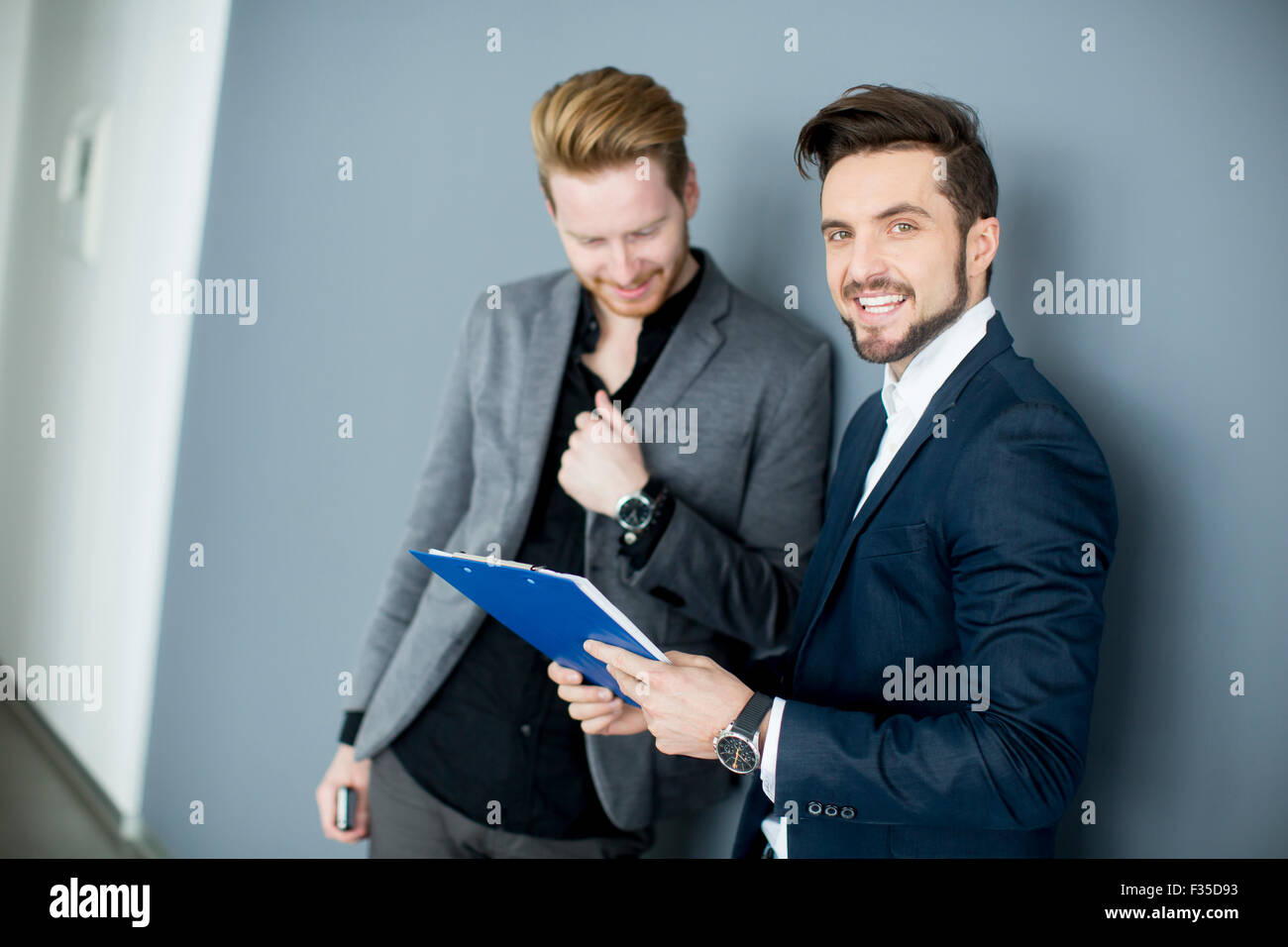 Young men standing in the office Stock Photo - Alamy