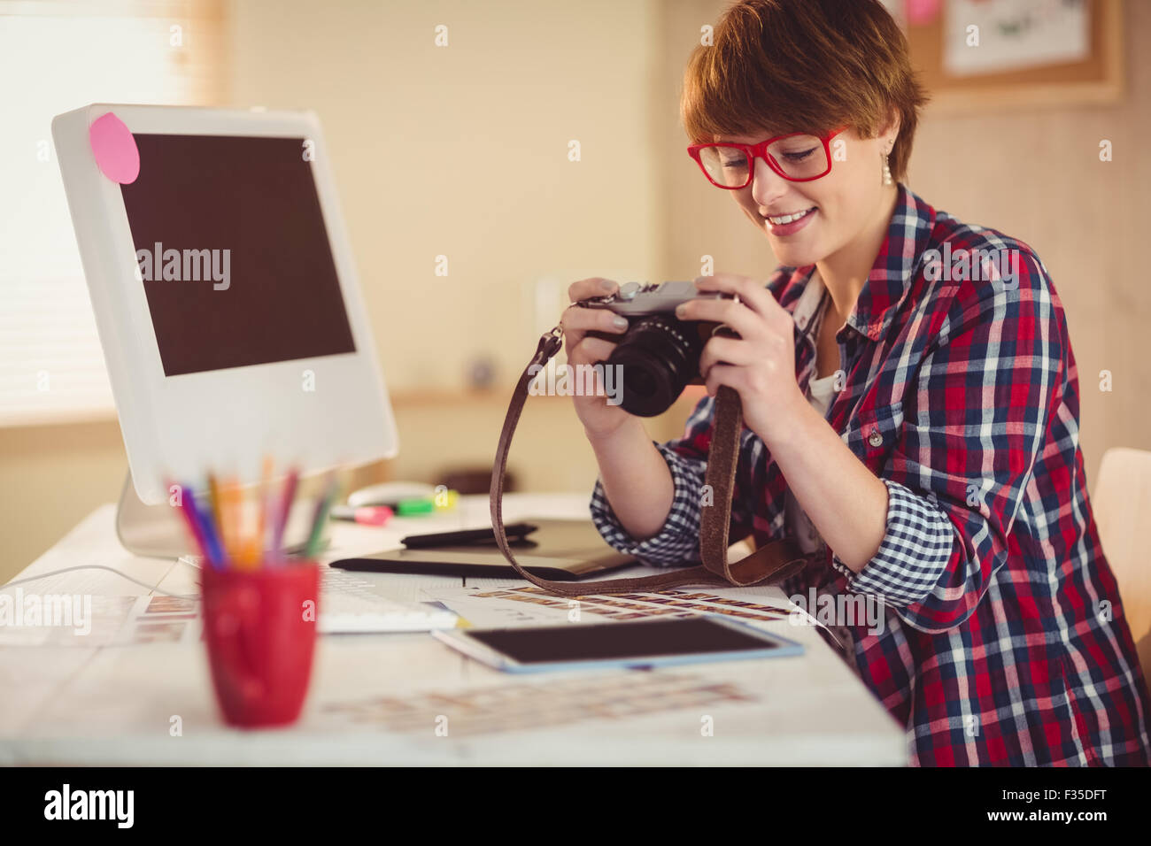 Smiling photographer looking at her camera Stock Photo - Alamy