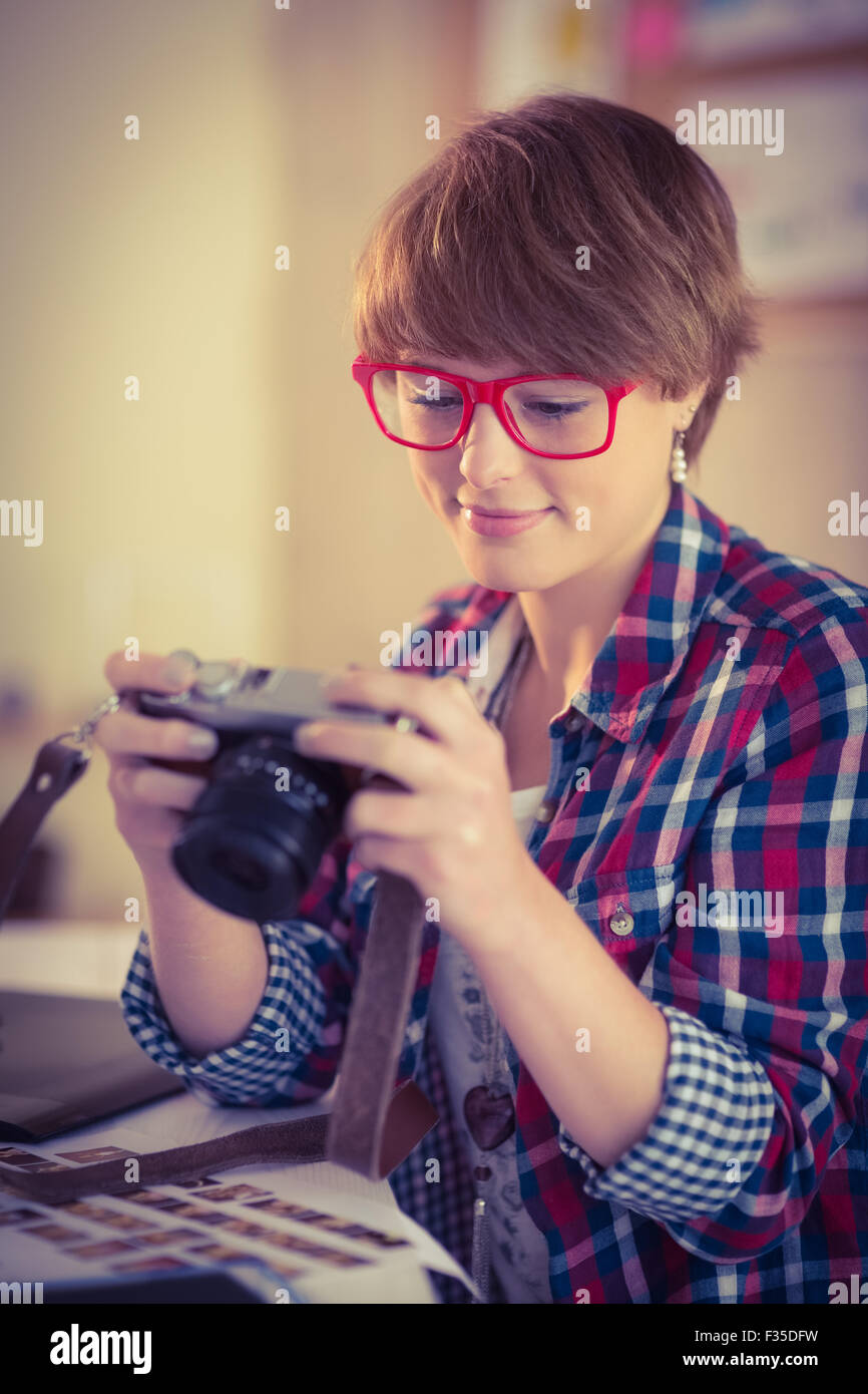 Smiling photographer looking at her camera Stock Photo - Alamy