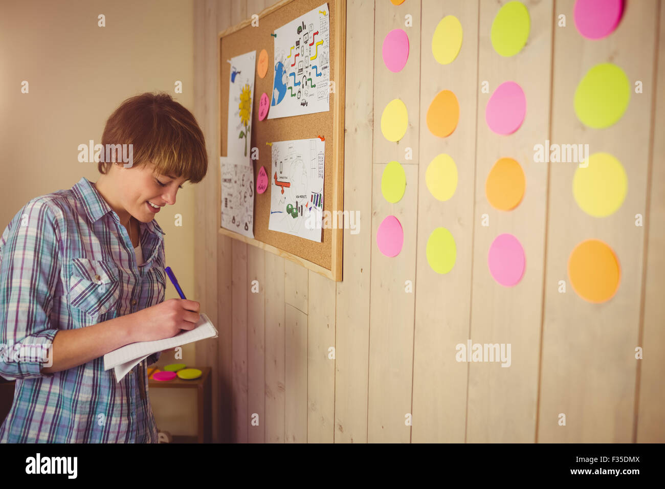 Smiling young woman taking notes Stock Photo - Alamy