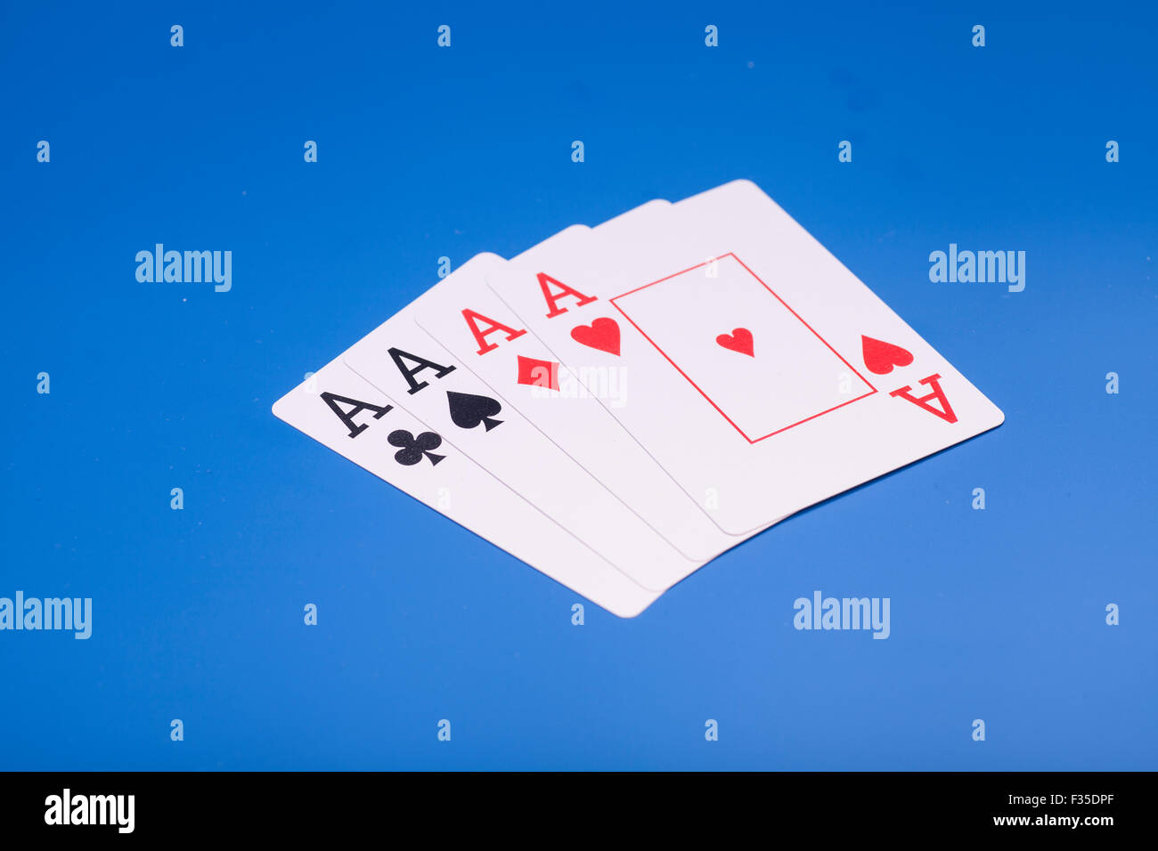 Four aces isolated on blue background Stock Photo - Alamy