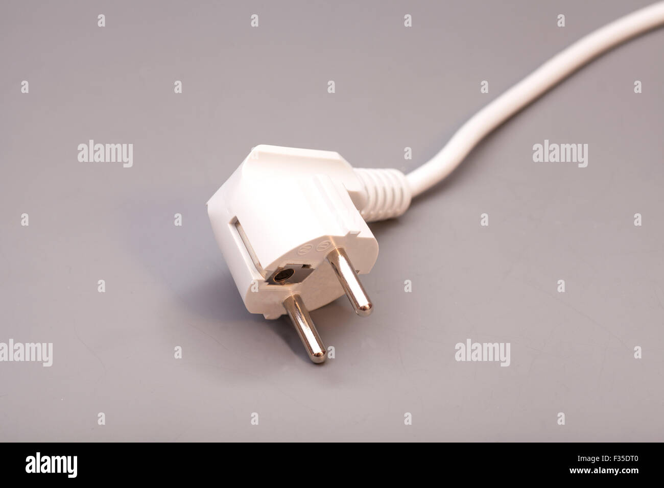 White plug isolated on gray background Stock Photo - Alamy