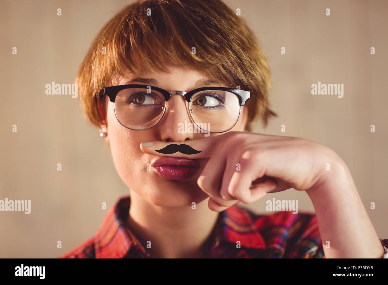 Pretty young woman with mustache on finger Stock Photo - Alamy