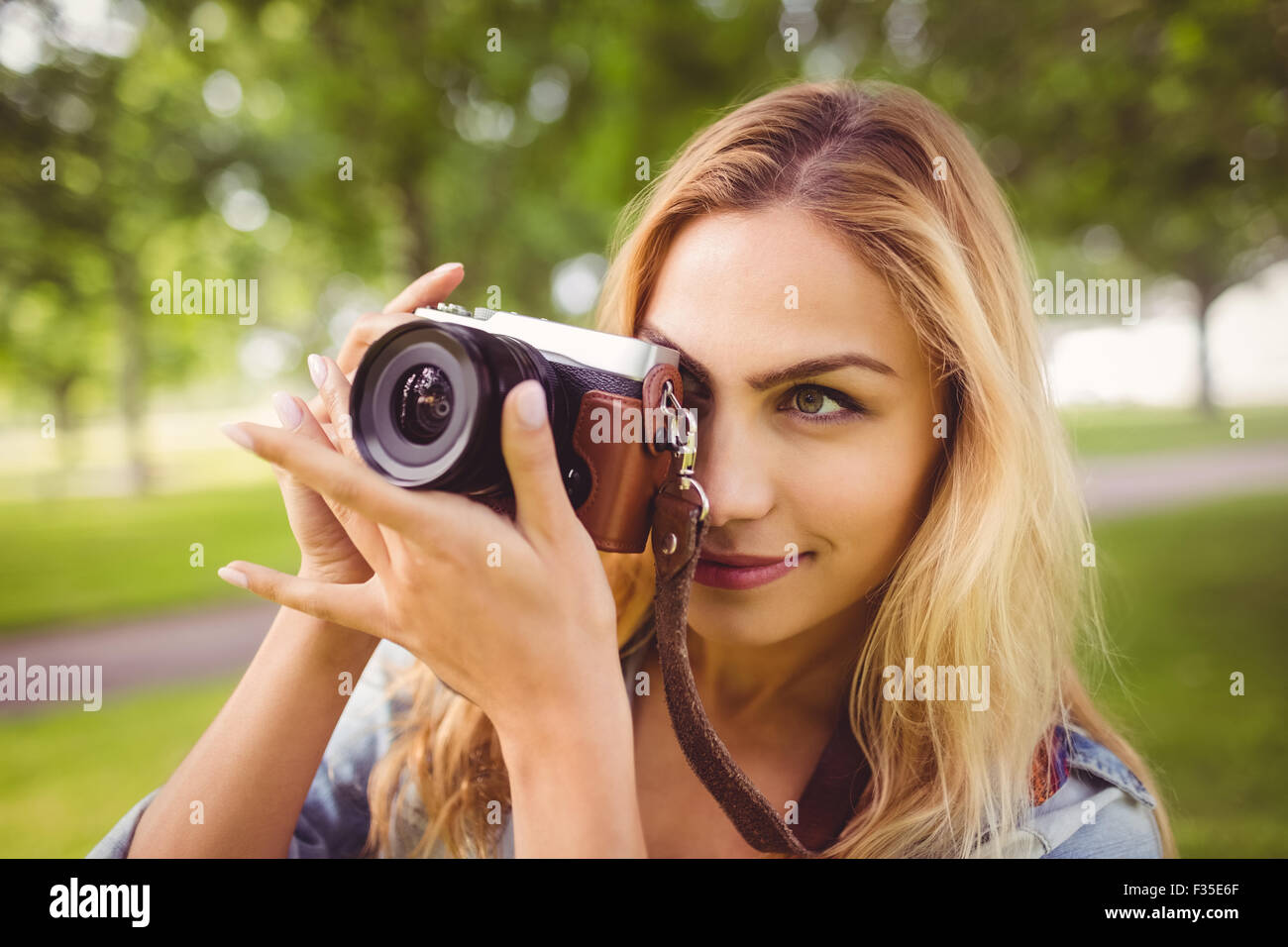 Happy woman taking picture with camera Stock Photo - Alamy