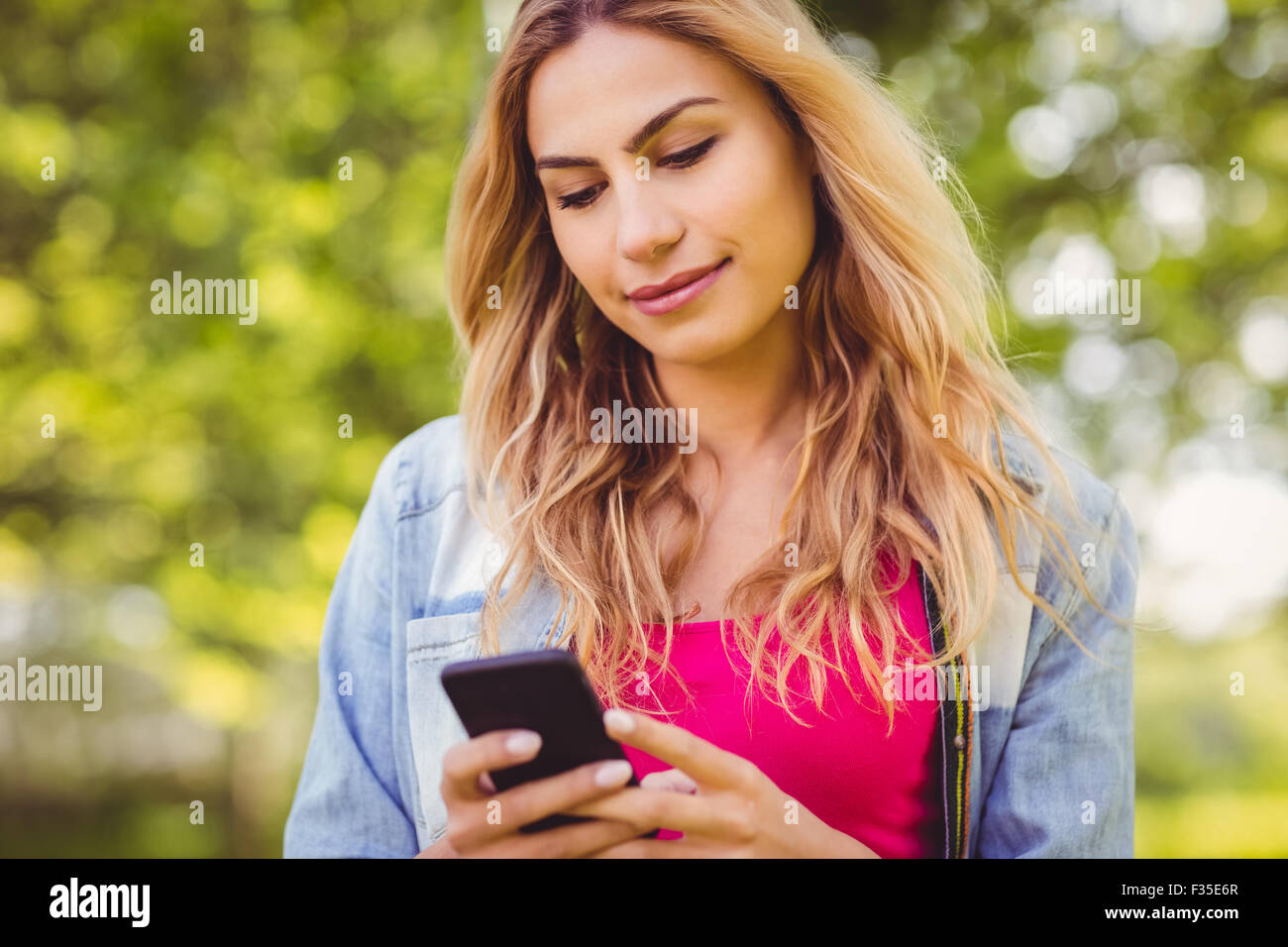 Smiling woman using mobile phone Stock Photo - Alamy